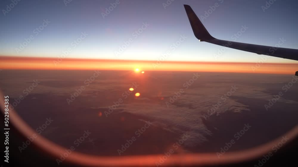 Looking out of window of flying at sunrise airplane. Point of view 4k ...