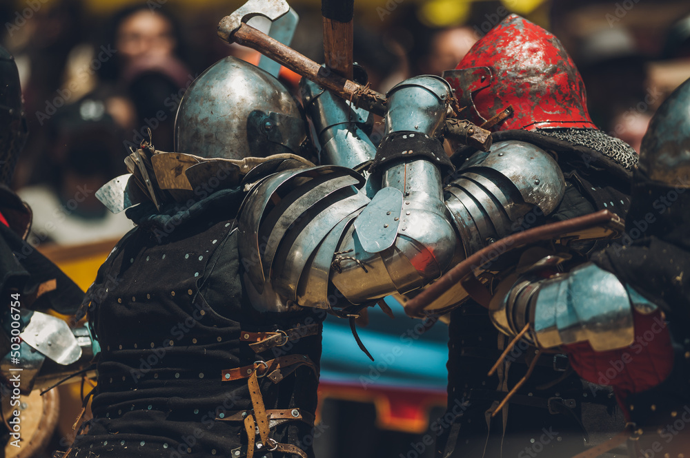 Pitch battle of medieval knights, using metal armor, axes, swords and ...