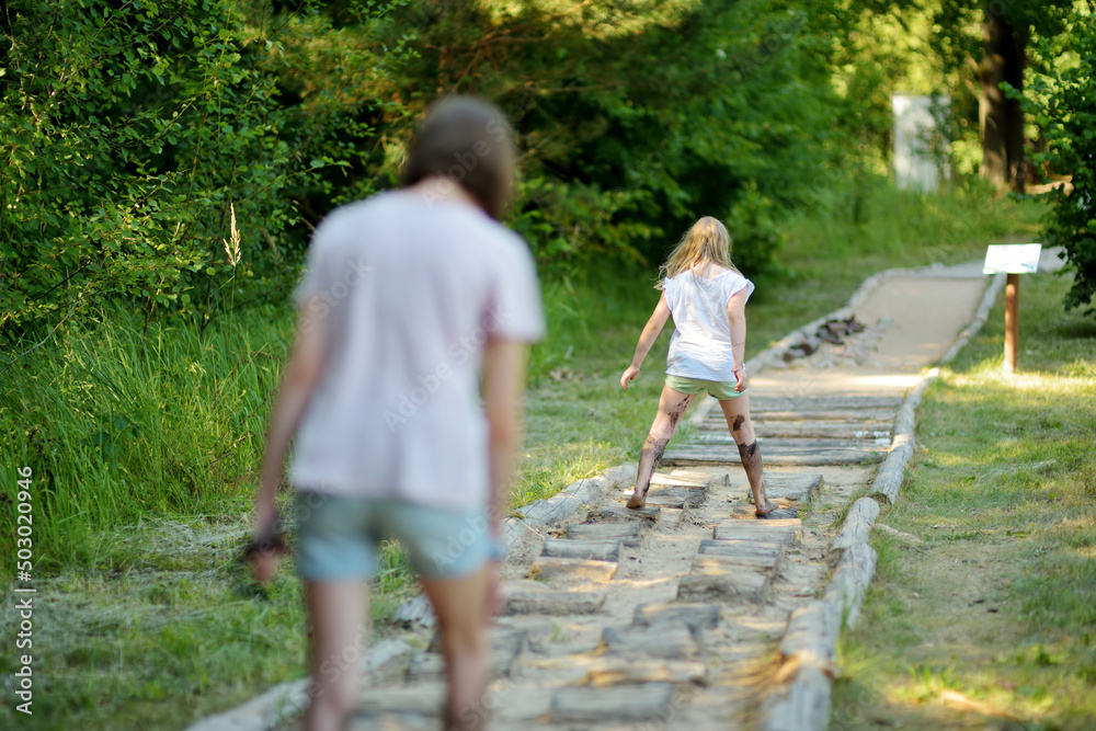 Two sisters on tactile path in barefoot park created to feel the ground ...