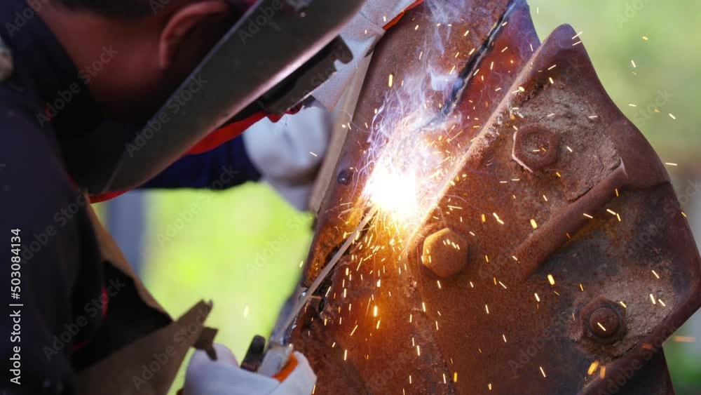 4K Man welder wearing safety equipment working on welding machine in ...