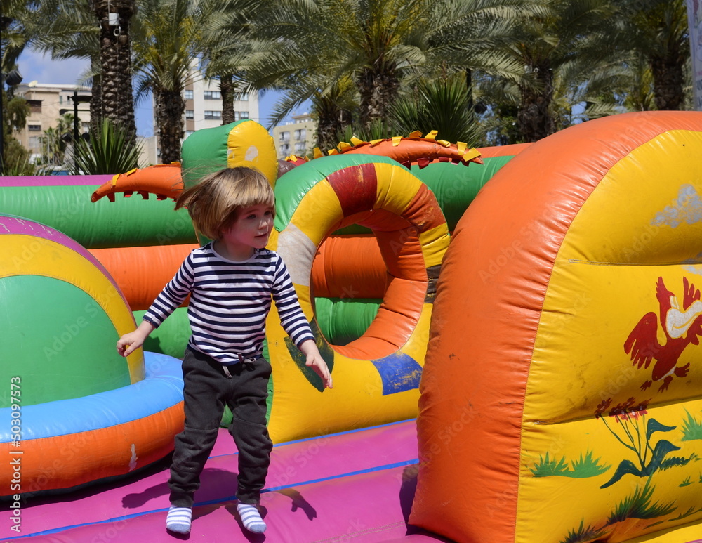 Child jumping on colorful playground trampoline. Kids jump in ...