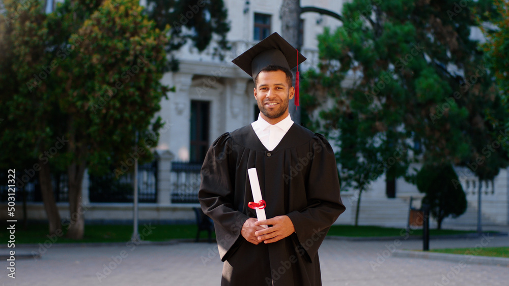 Good looking guy in his graduation day wearing a suit and graduation ...