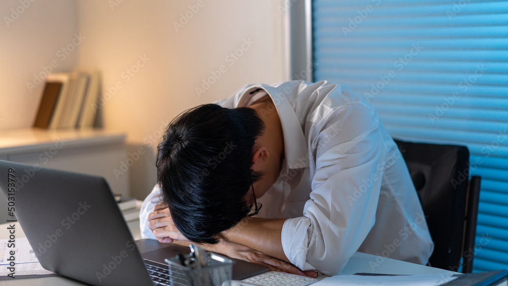 Overwork Concept The man who works late in the office lying his head on ...