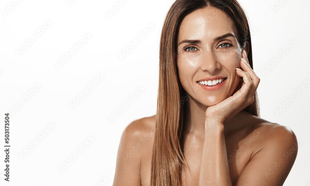 Beauty portrait of mature woman smiling with hand on face. Closeup face ...