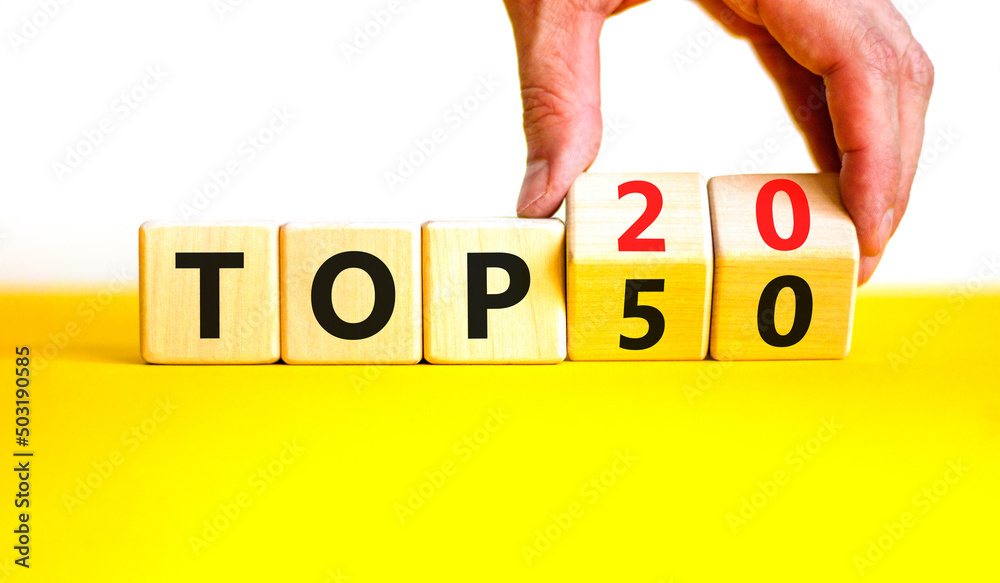From Top 50 to 20 symbol. Businessman turns wooden cubes and changes ...
