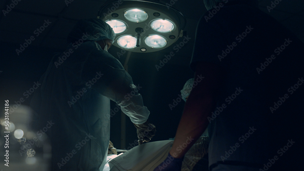 Professional surgeon stitch incision in operating room. Intensive care ...