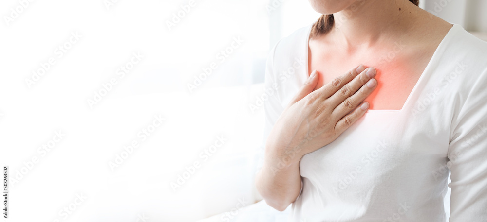 Young woman putting her hand on her chest. Having a pain in chest ...