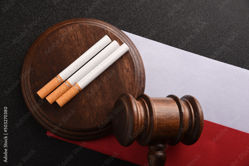 Top view three cigarettes and wooden Judge gavel on polish flag ...