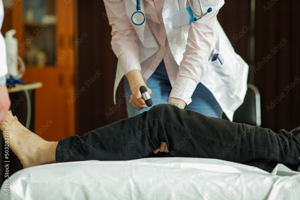 Details with the hands of a young female medic testing the knee ...