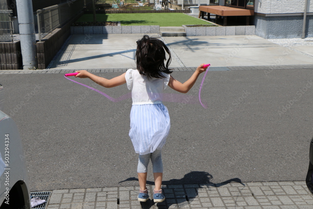 縄跳びをする女児の後姿 Stock 写真 | Adobe Stock