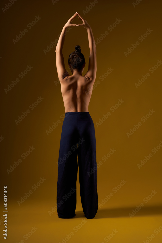 Back view of sporty female practicing yoga pose at studio. Flexible ...
