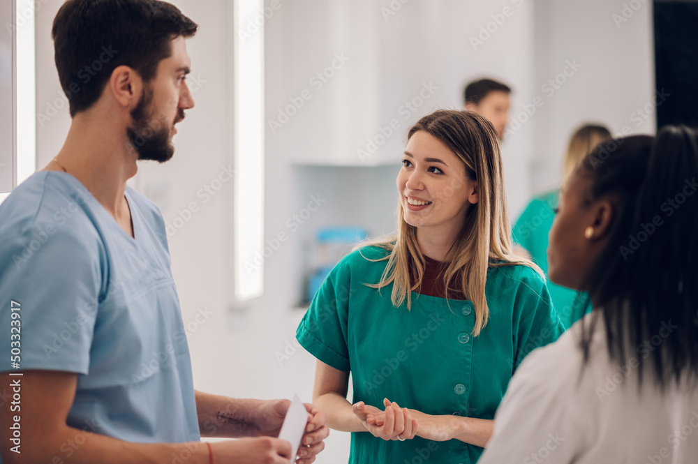 Multiracial team of doctors discussing a patients condition while ...