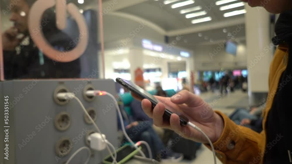 Video „Close-up, a man uses a phone and charges it in a special place ...