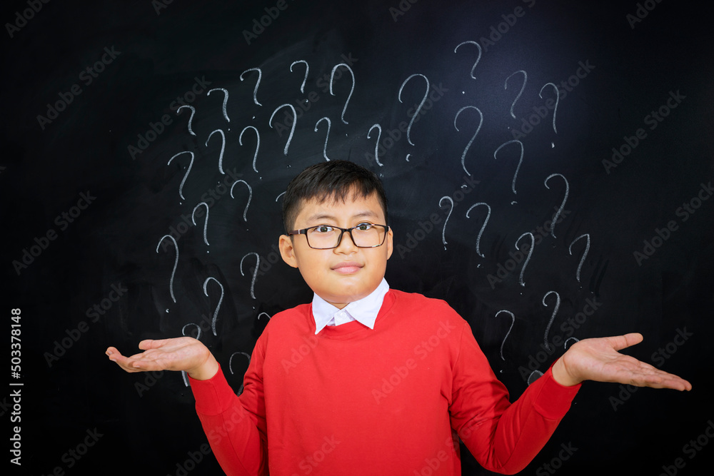 Confused little boy with question marks in class Stock Photo | Adobe Stock