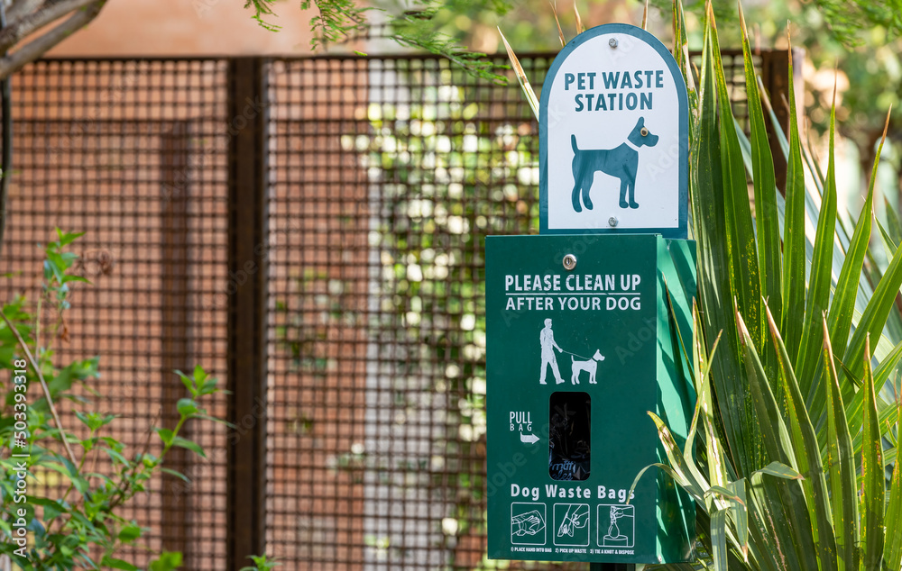 Pet waste station in park with plastic bags and instructions for use ...