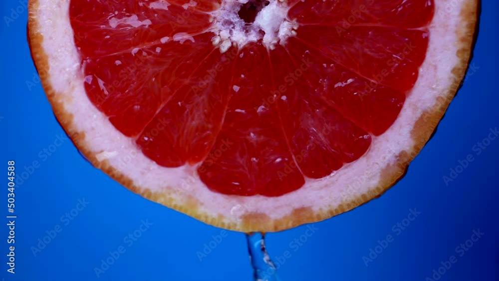 juicy pulp of fresh red grapefruit in blue background, fresh water or ...