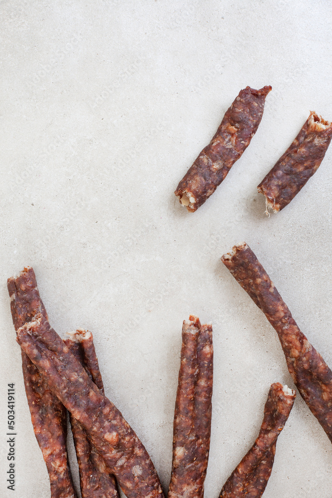 South African Dry Wors, a dried and cured sausage snack on grey, with ...