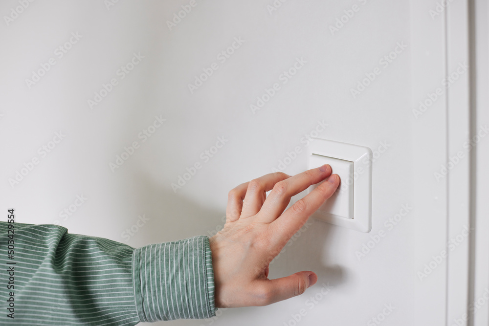 Hand pressing light switch Stock Photo | Adobe Stock