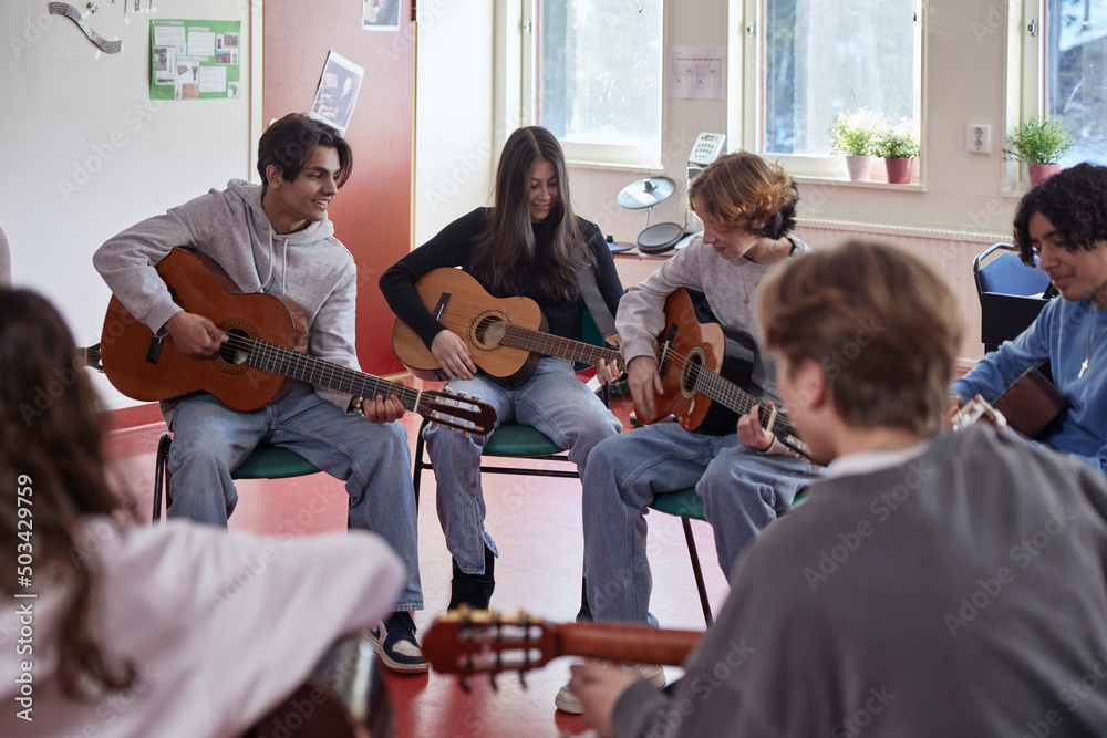 Teenagers attending guitar lesson Stock Photo | Adobe Stock