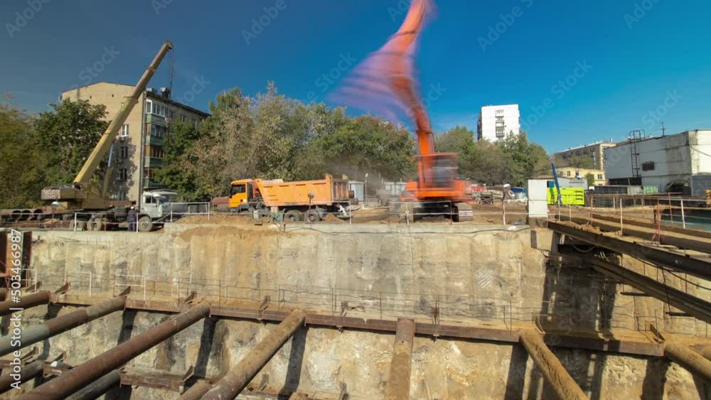 Excavator and truck working on a huge ditch pit at the construction ...