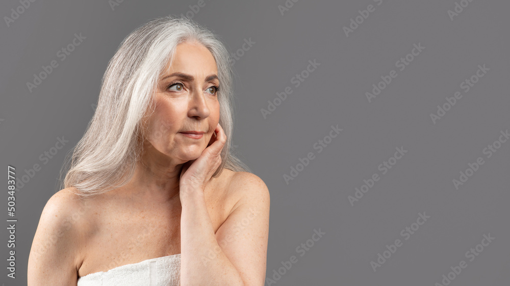 Graceful aging concept. Attractive senior lady touching skin on her ...