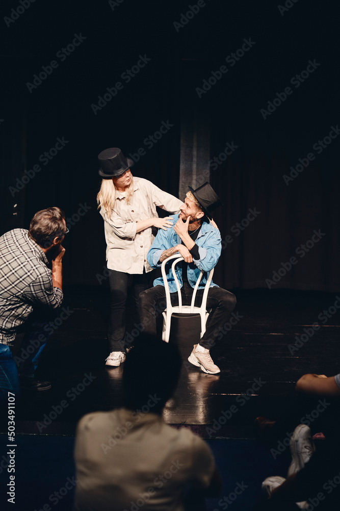 Full length of actress rehearsing with man sitting on chair while ...