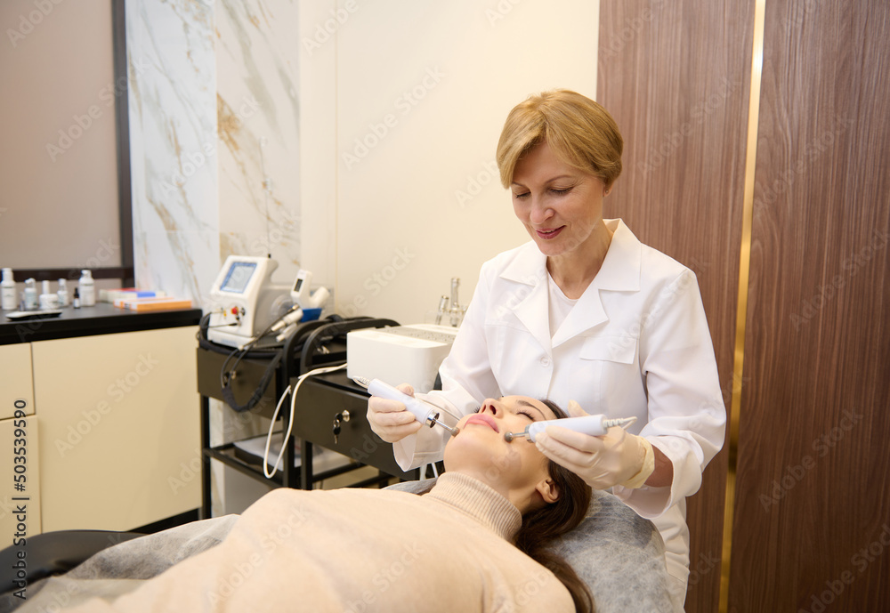 Doctor cosmetologist performs a rejuvenating procedure for facial skin ...