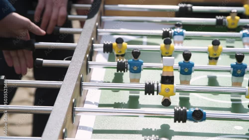 Man actively twists handles of table kicker with his hands on sunny day ...