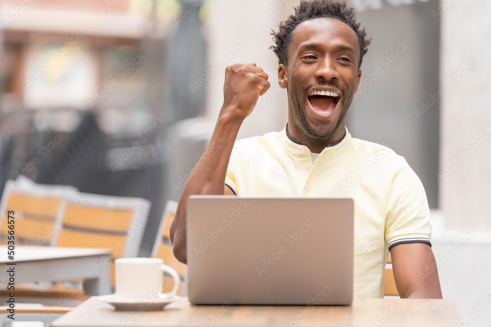 Excited man with black skin checking laptop computer celebrating in a ...