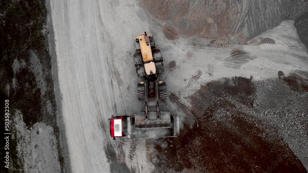 Wheel loader load gravel and crushed stones in dump truck. Front end ...