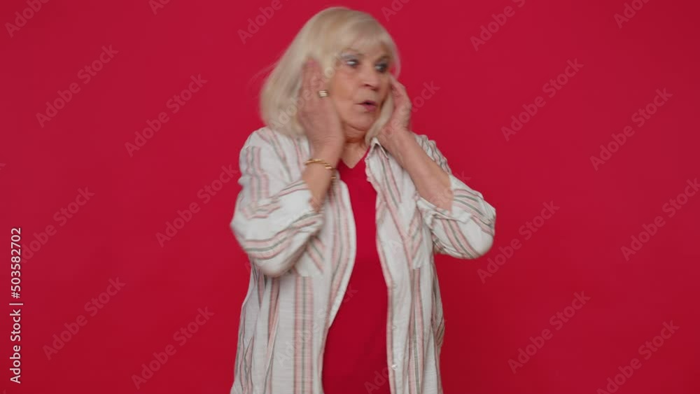 Elderly mature woman scared fearful, covering ears with hands, closing ...