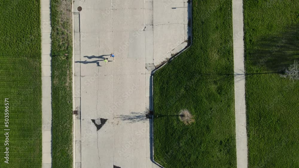 Top down view of cracked cement street. No people. Parallel sidewalks ...