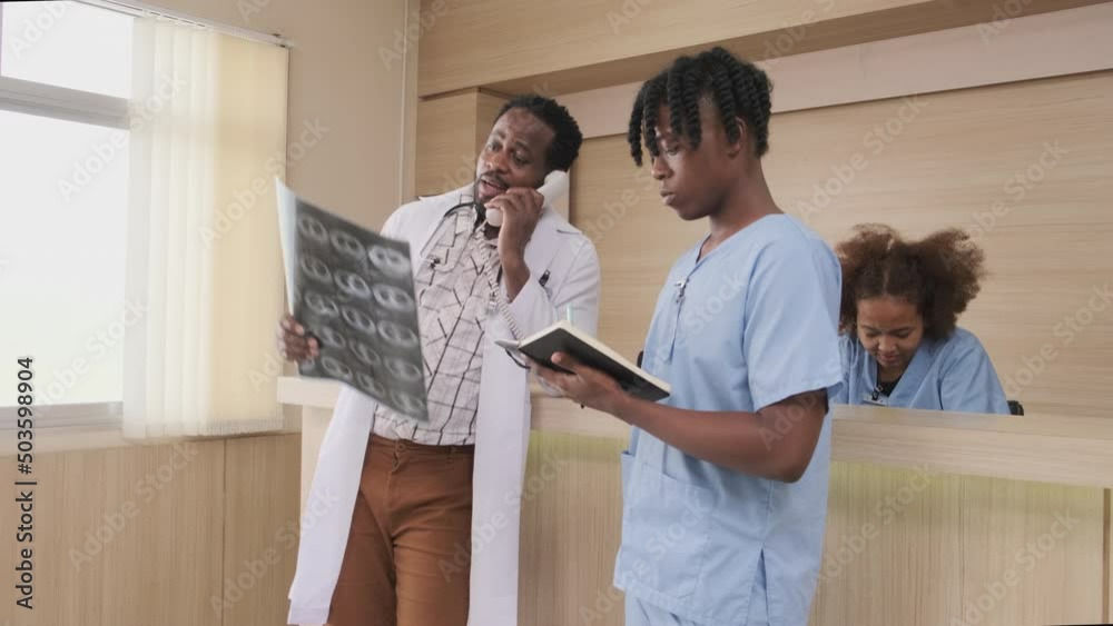 Professional African-American male doctor talks phone about a patient's ...