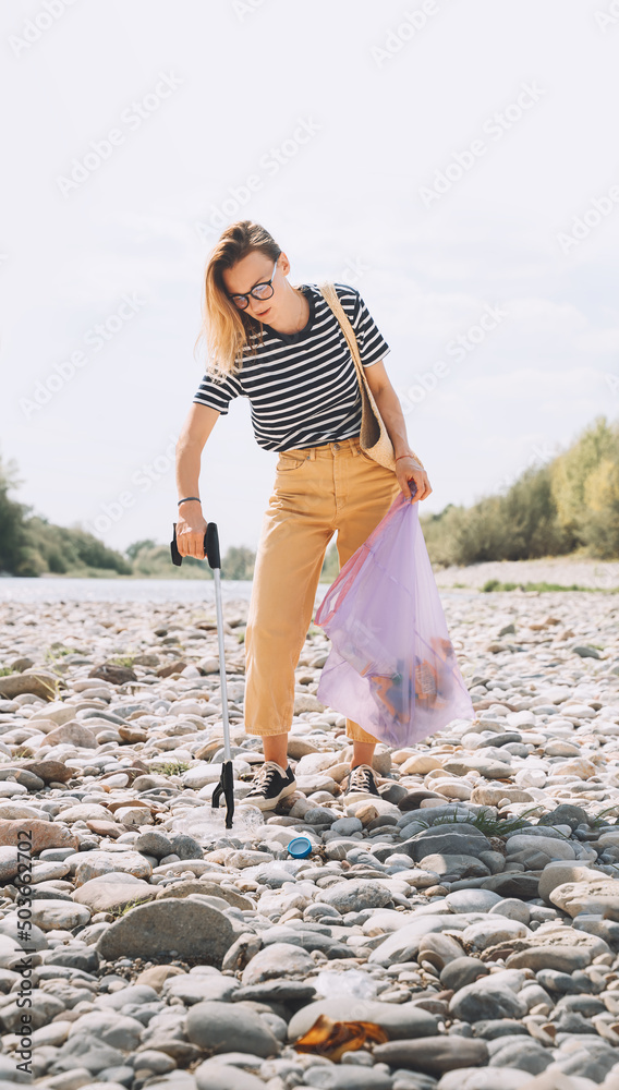 Person help to keep nature clean up and pick up garbage. Young woman ...