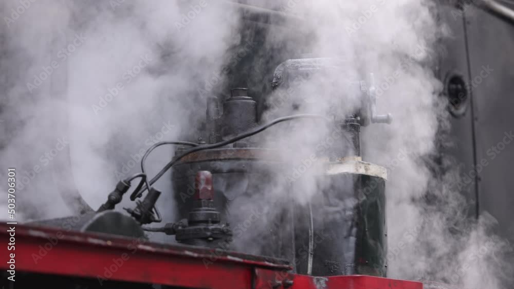 Smoke covering the train. Retro steam locomotive departs from the ...