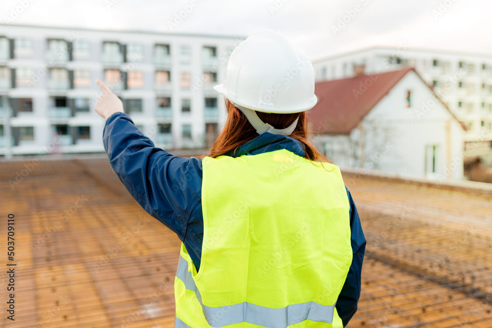 Architect redhead woman wearing contractor white helmet and safety ...