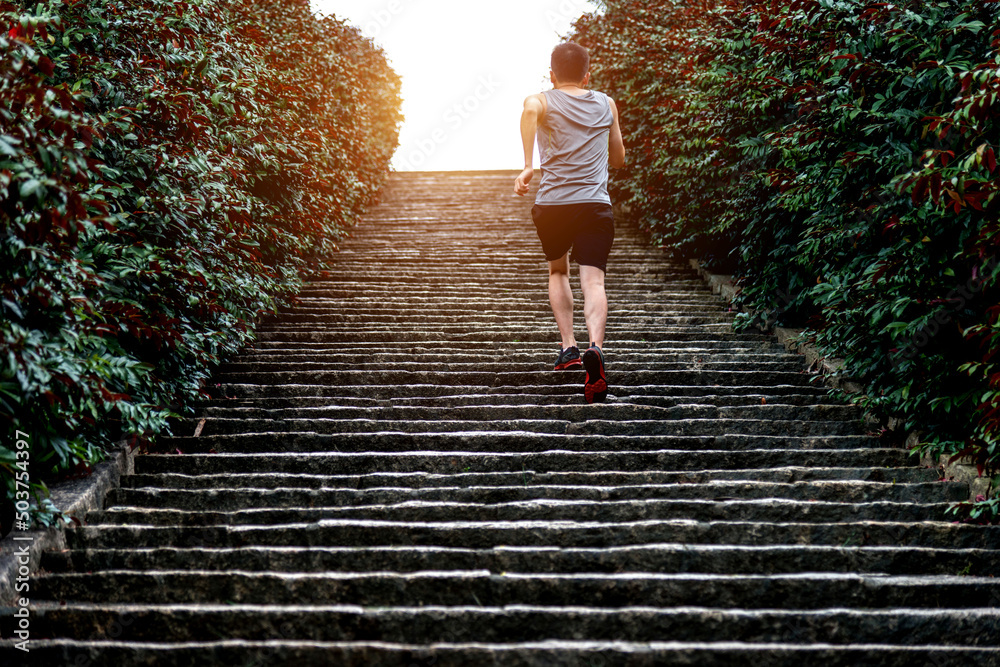 Rear view of young man running on stairs Stock-Foto | Adobe Stock