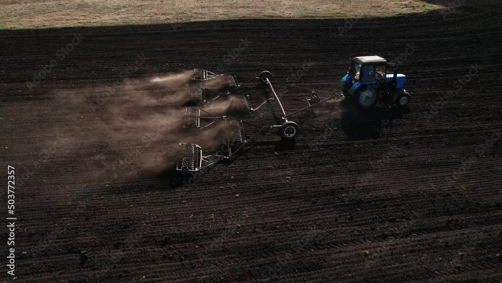 Video Stock Farm tractor with rotary harrow plow preparing land for ...