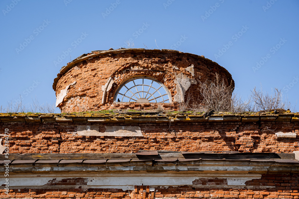 A fragment of an old red brick building, an ancient round-shaped ...