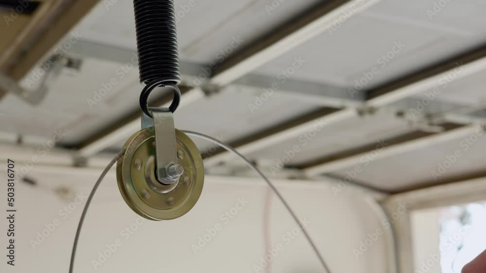 A homeowner or handyman type installing a new pulley cable on the ...