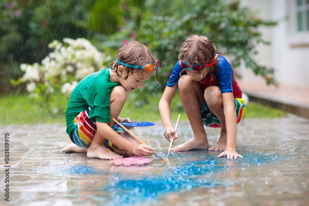 Kids playing in the rain. Chalk drawing fun. Stock Photo | Adobe Stock