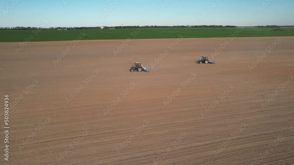Tractor sowing seed on plowed field, drone view. Seeding machinery for ...