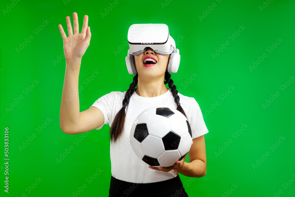 Asian woman in vr glasses, virtual reality headset, holding a soccer ...