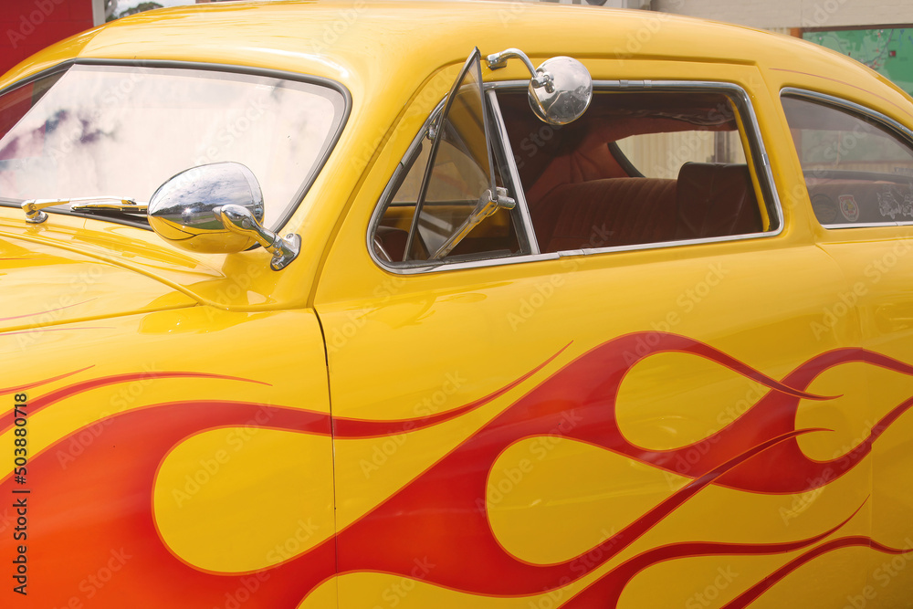 Side of classic vintage car with flames painted on the side. The hot ...