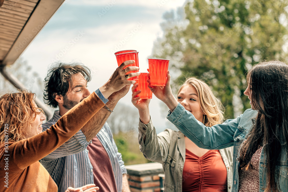 friends drinking and toasting on plastic cups - young people having fun ...