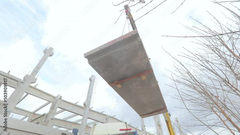 A crane lifts a concrete ladder. A crane lifts a concrete slab ...