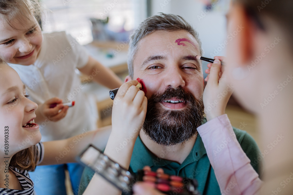 Photo Stock Three little girls putting on make up on their father ...