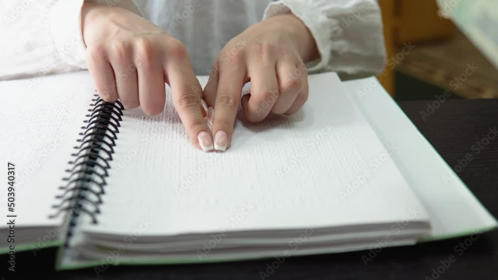 Hand touches the description in Braille. Female student studying in a ...