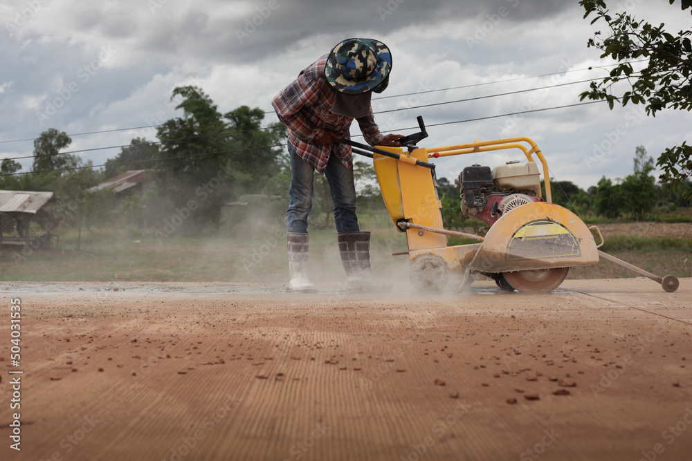 Workers at a concrete road construction site Road cutter is being used ...