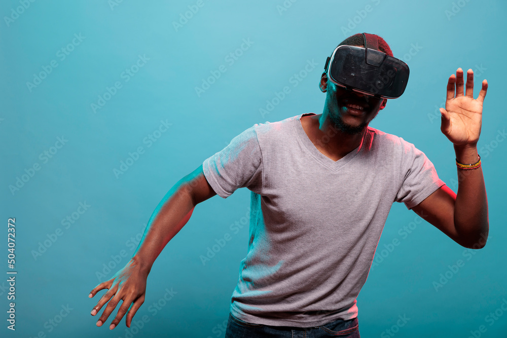 Cheerful person raising hands and playing with futuristic vr goggles to ...